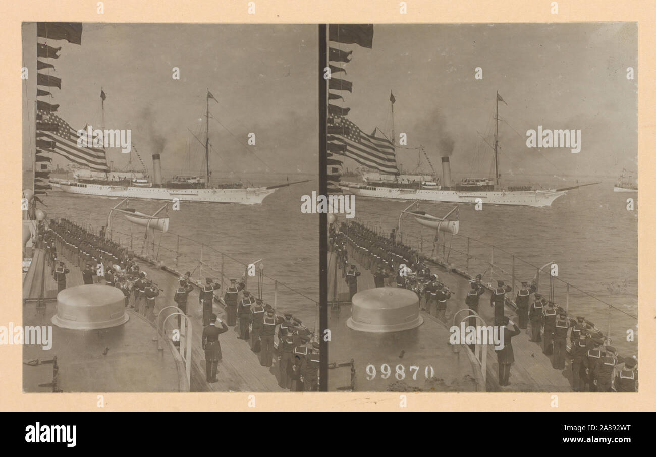 Sailors and marching band on deck of ship saluting a ship passing by ...