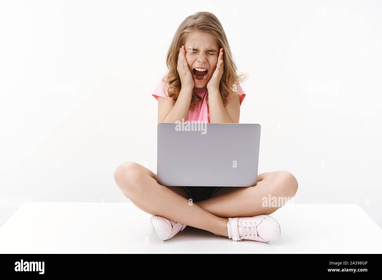 Scared terrified young cute caucasian blond girl scream from fear, sit ...