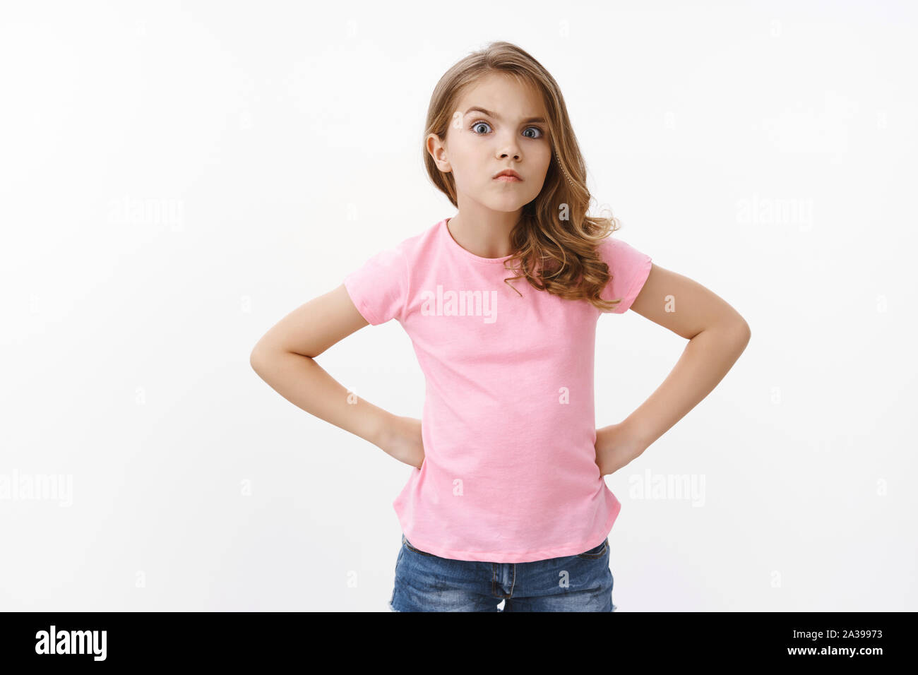 Serious-looking strict and angry little arrogant girl, blond child ...