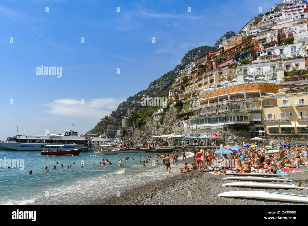 POSITANO, ITALY - AUGUST 2019: Surf boards and people on the beach in ...
