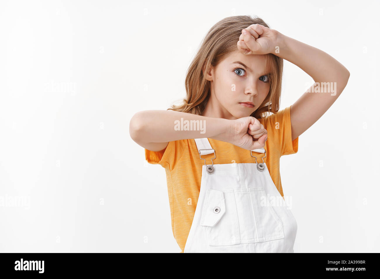 Serious-looking reluctant and restrained young girl protect face, raise ...