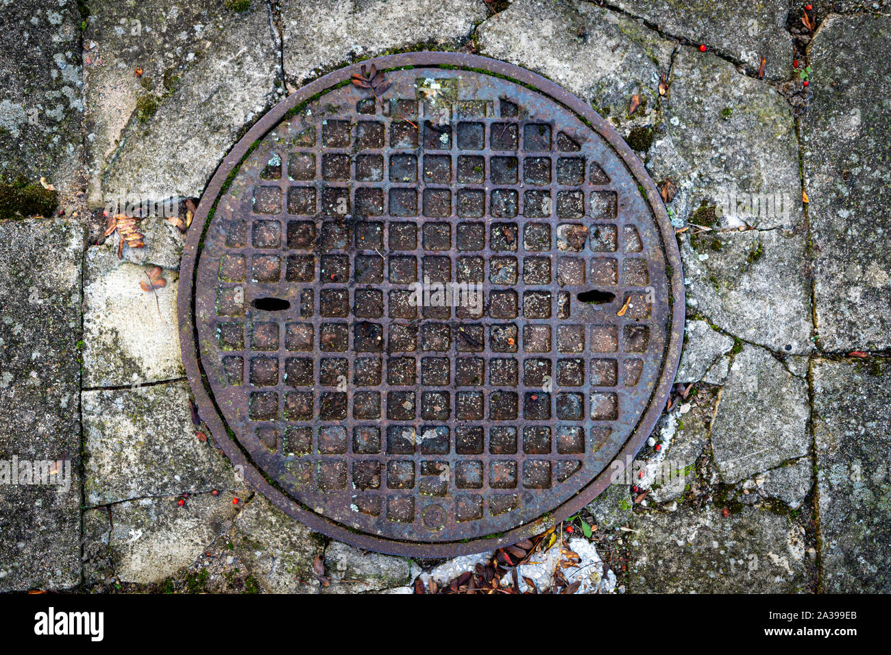 Cast iron round sewer pit. Rainwater installation in the city. Autumn ...