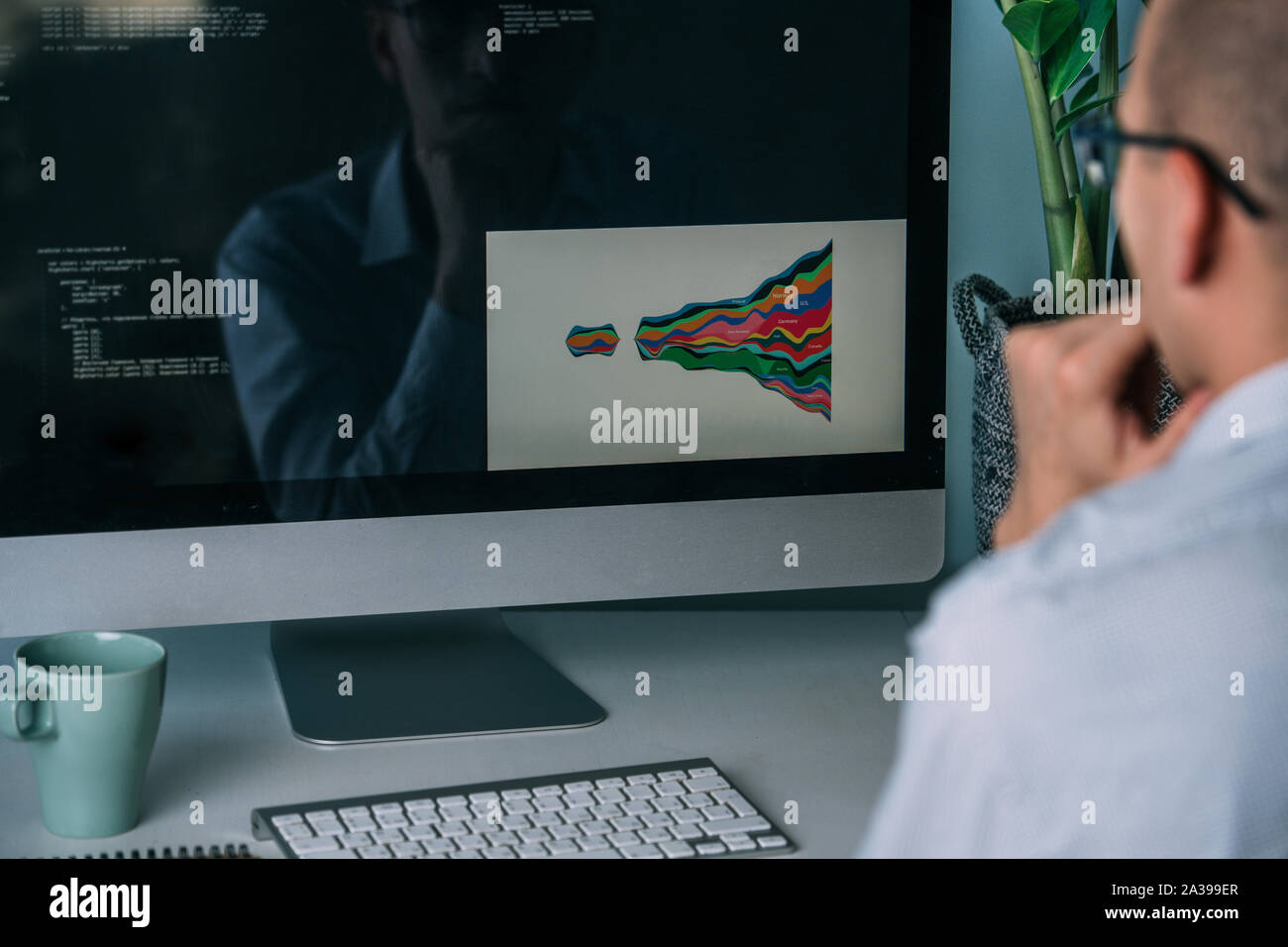 Developer Working Behind The Desk Analysing Diagram On The Monitor