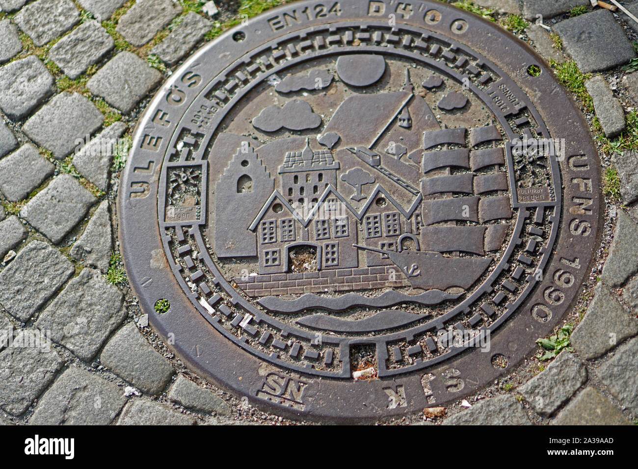 An iron-cast on the floor of a street in Bryggen, Bergen, Norway ...