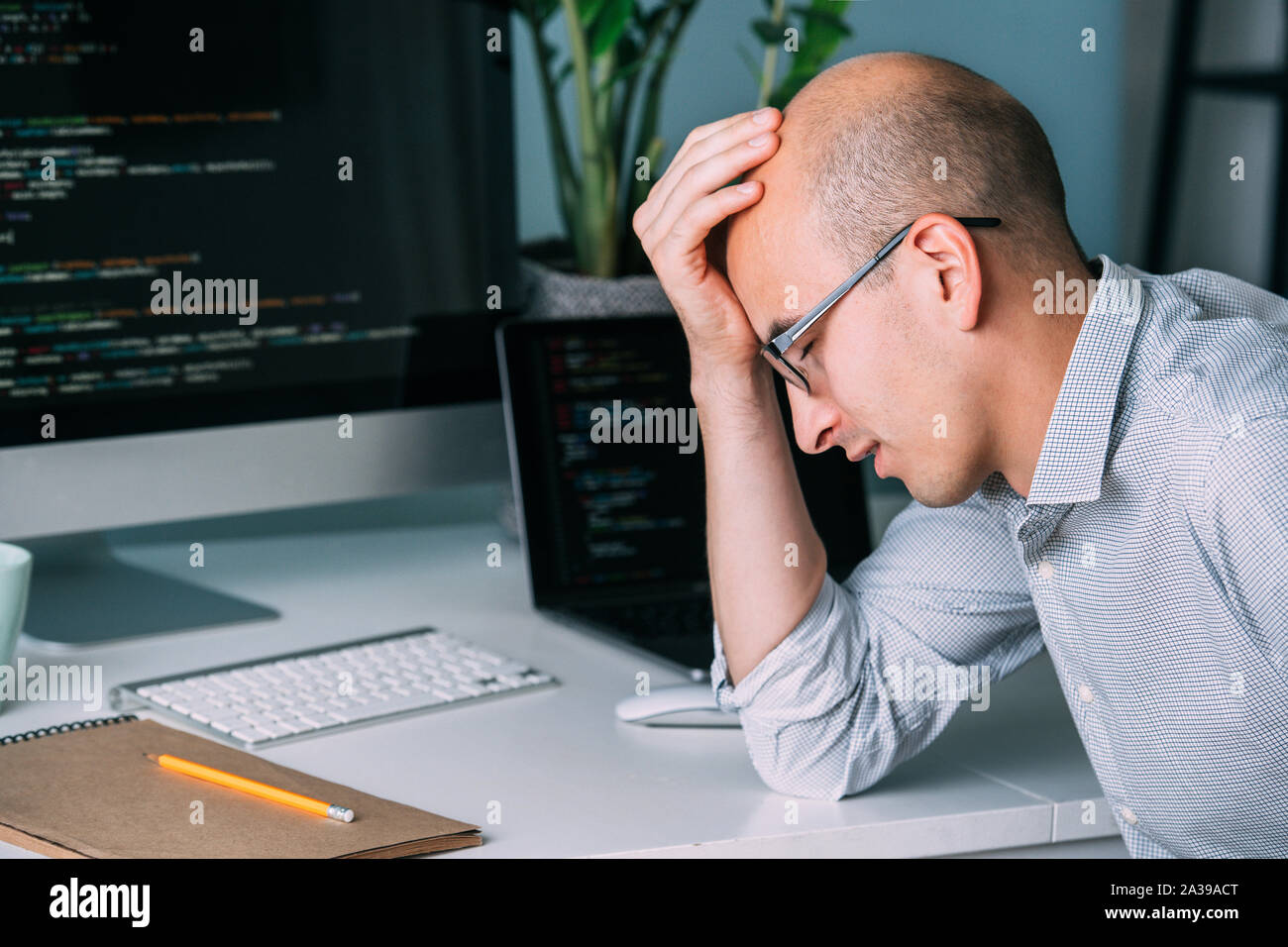 Programmer Working Behind The Desk Analysing Code On The Black Screen