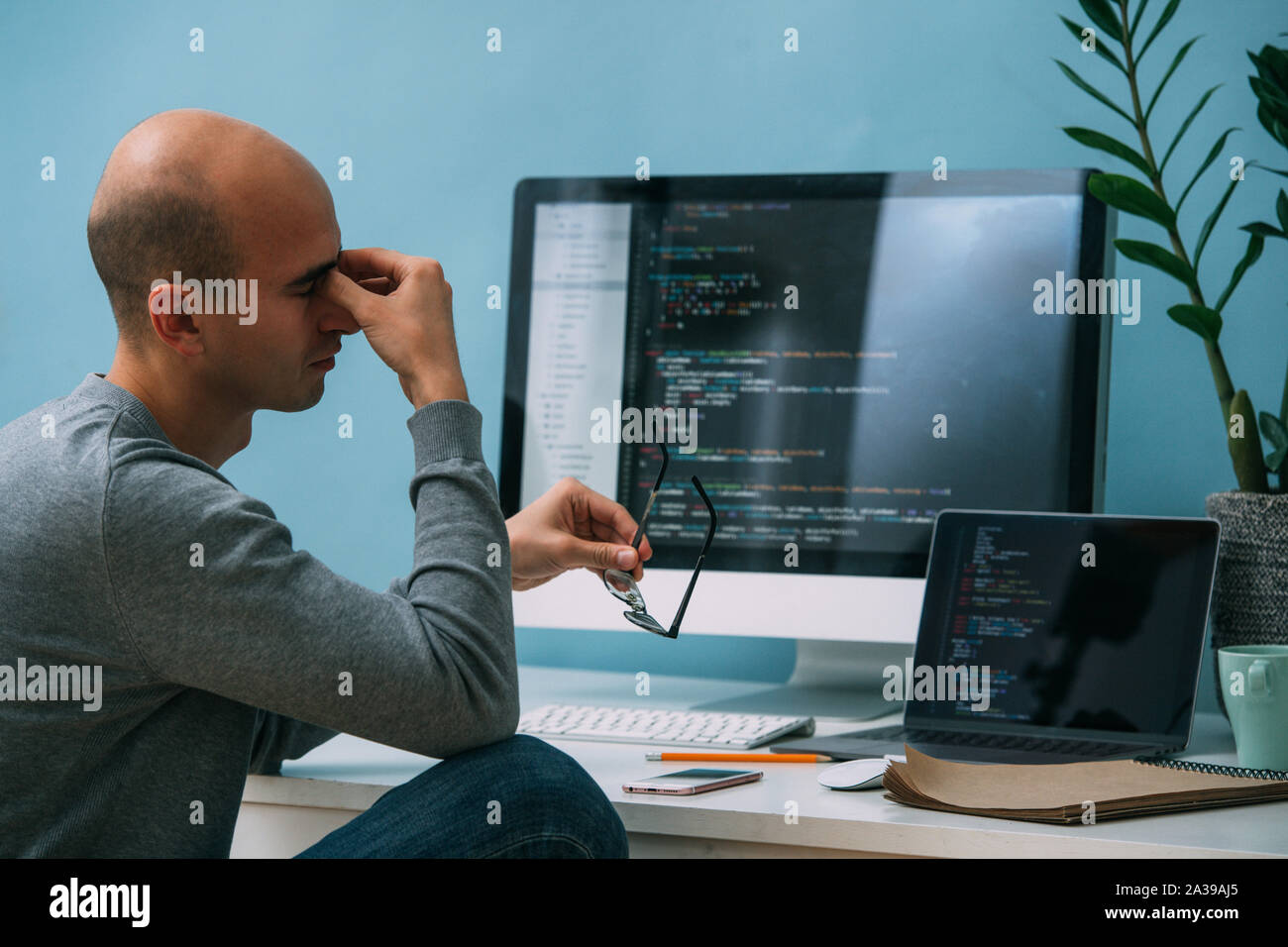 Programmer Working Behind The Desk Analysing Code On The Black Screen