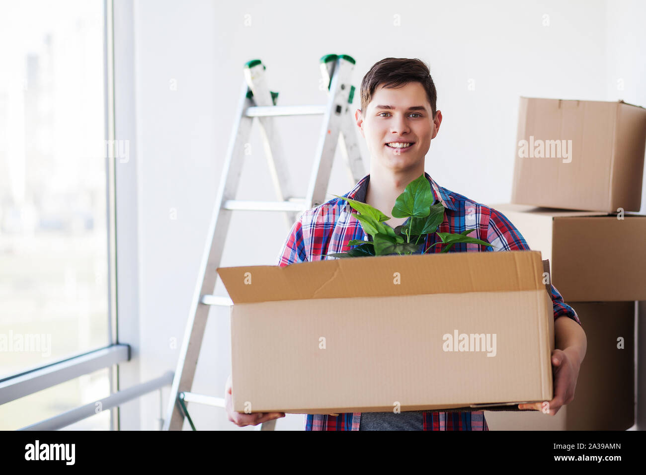 Happy young man moving to new home Stock Photo - Alamy