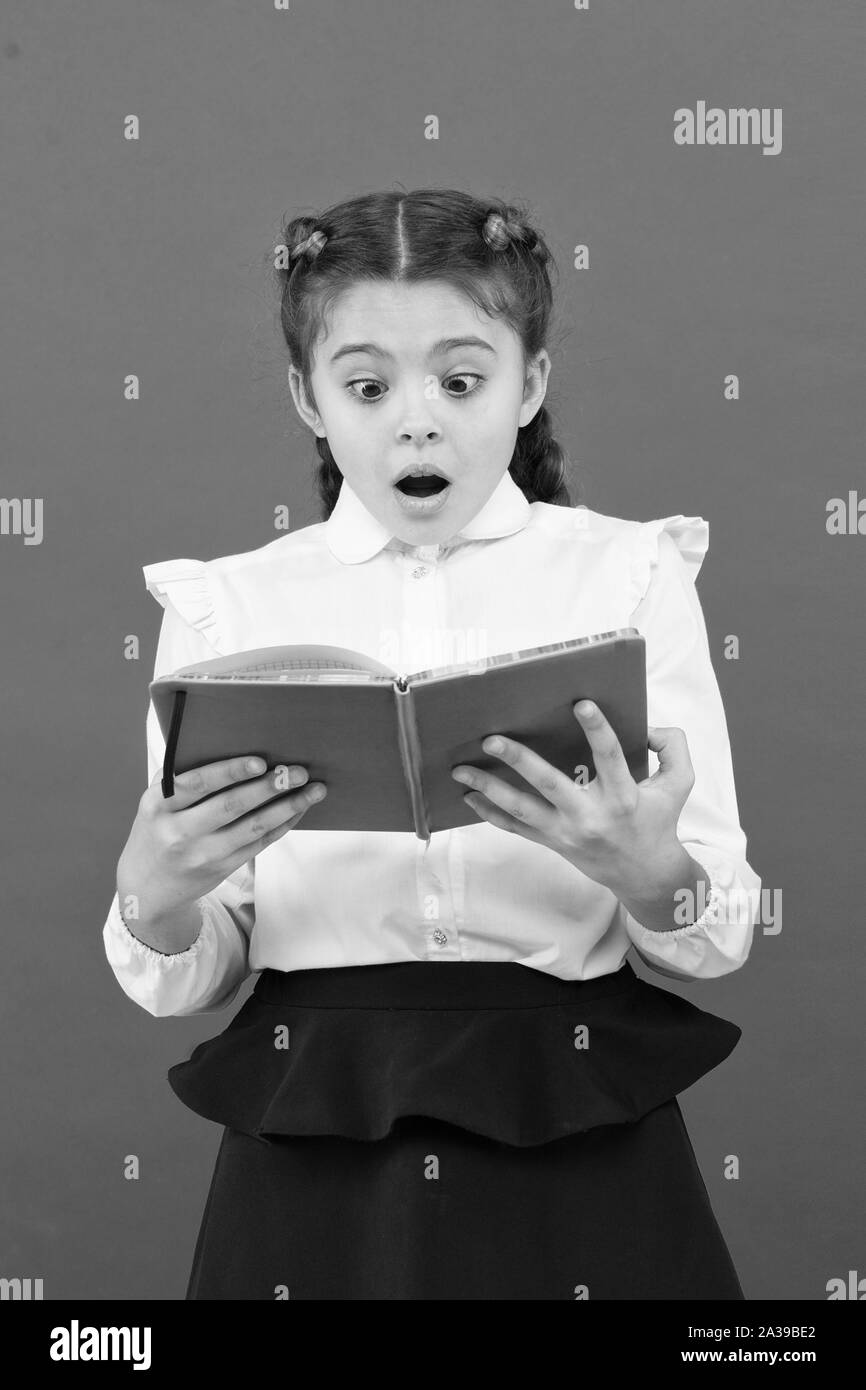 What a surprise news. Surprised girl reading book on red background ...