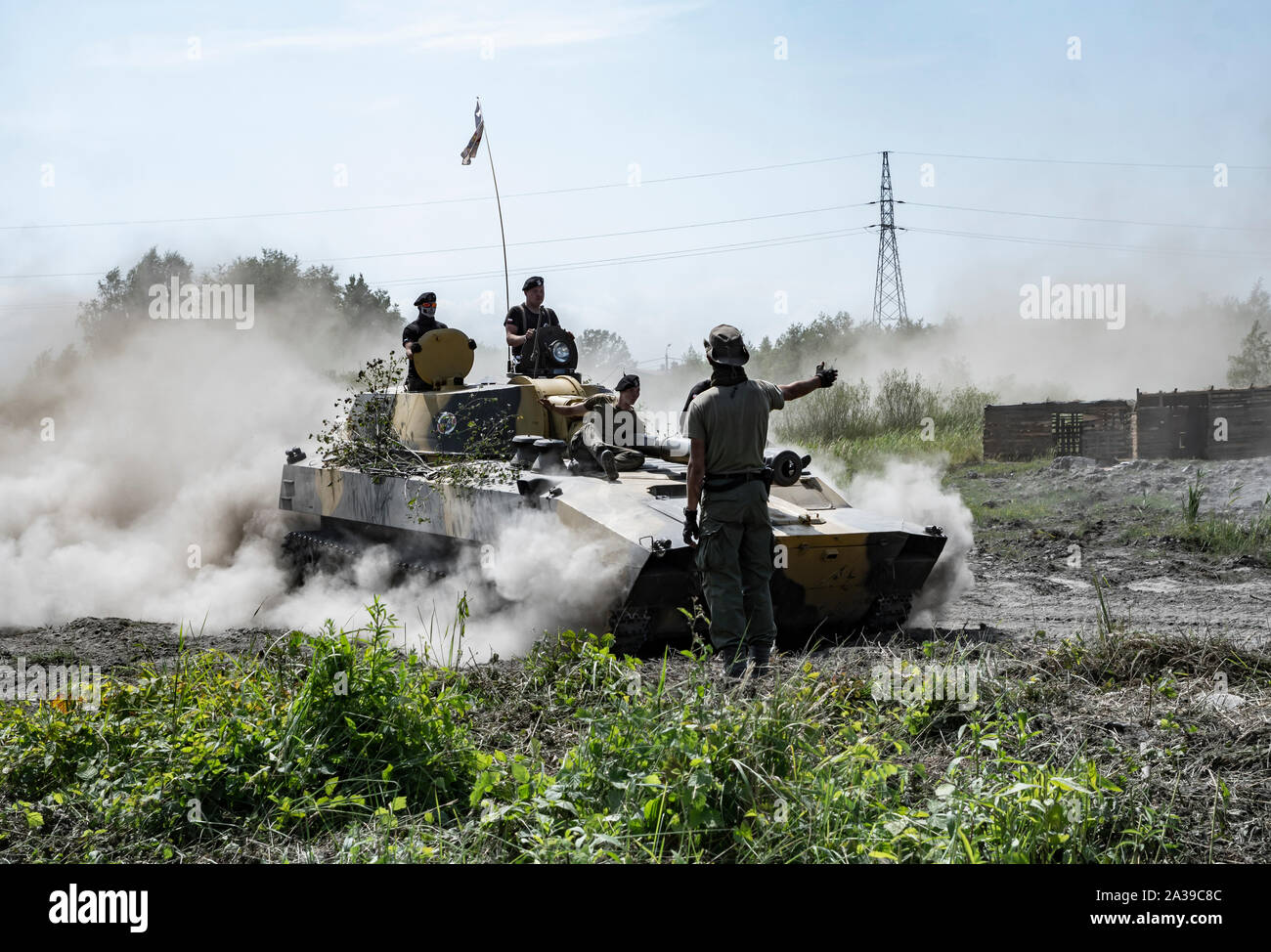 The man shows a signal to a fast moving of the Soviet 2S1 Gvozdika self ...
