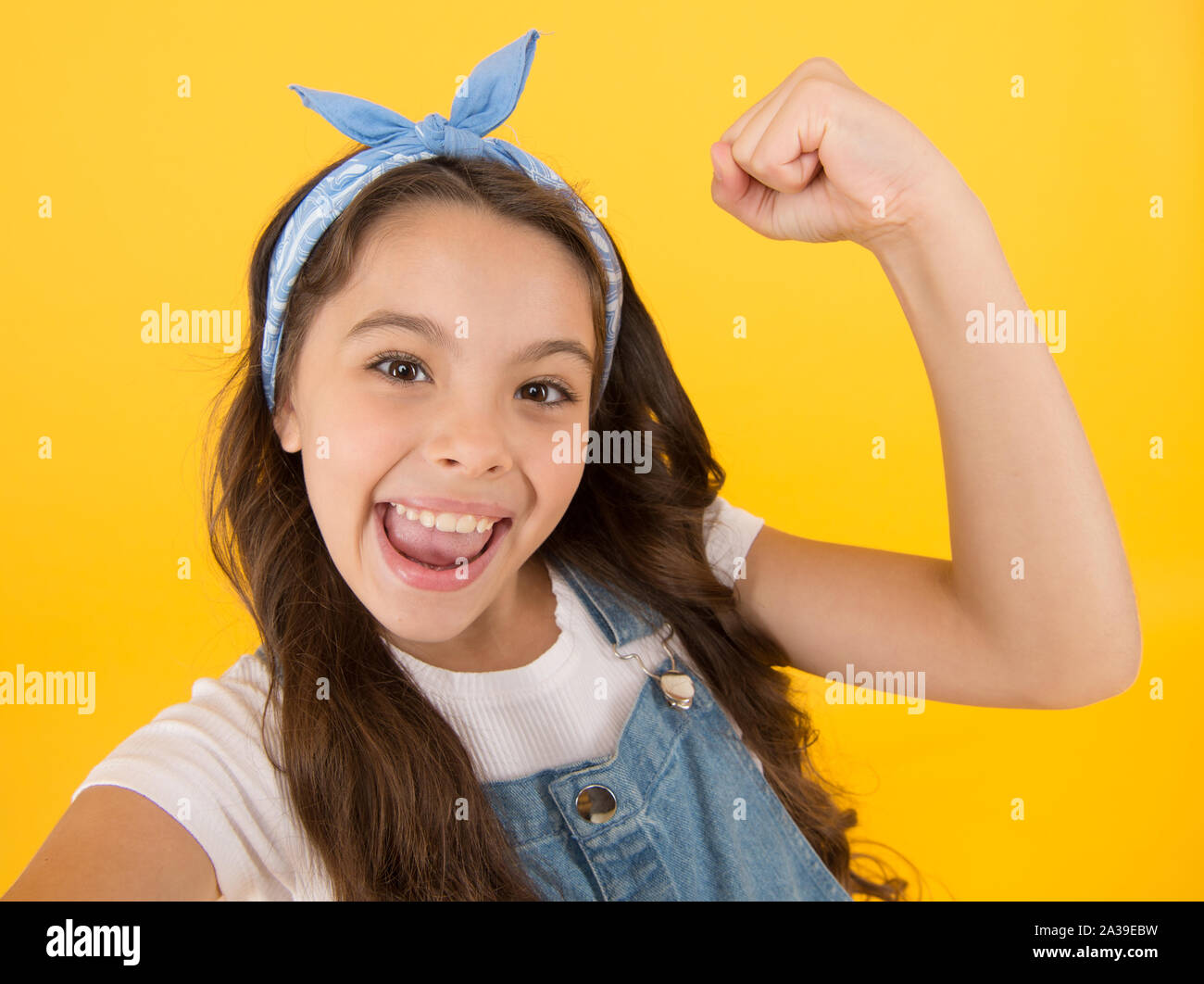 I did it. Happy little girl flex biceps on yellow background. Girls ...