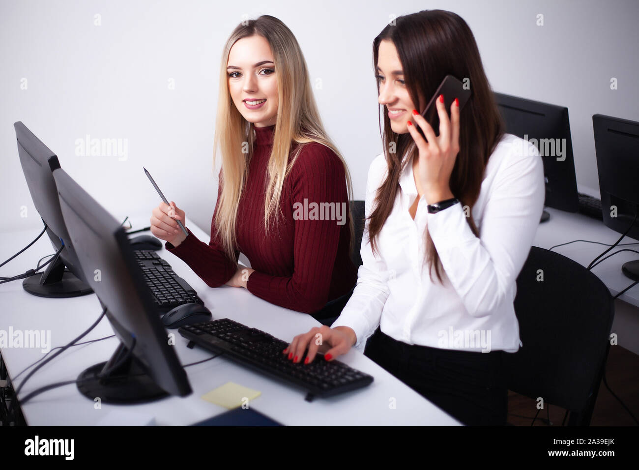 Two beautiful girls work in the office of a consulting company Stock ...