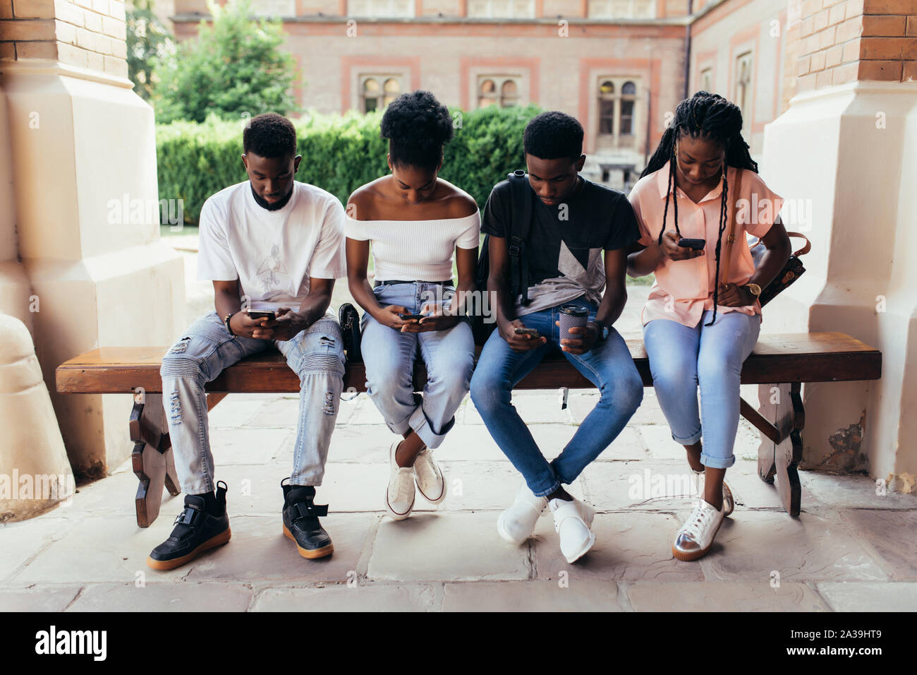 Group of african students networking using several tech devices ...