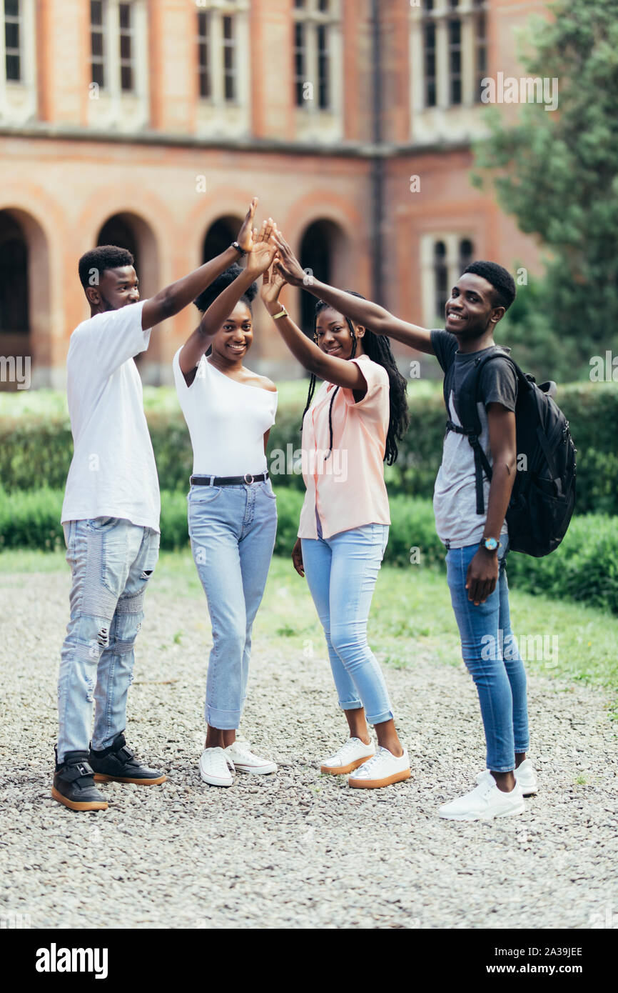 education and friendship concept - happy students giving high five at ...