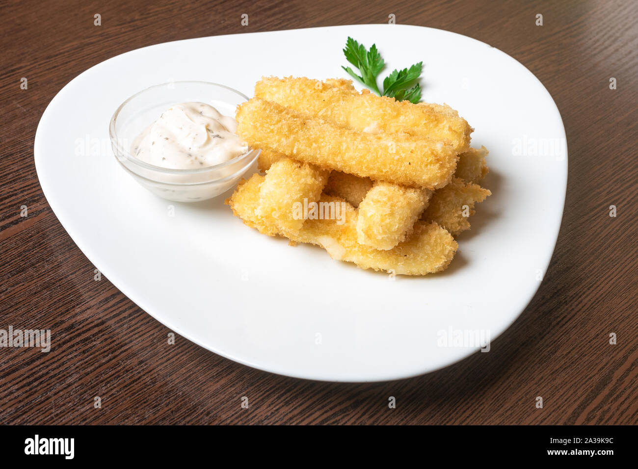 Cheese sticks breaded, with sauce and herbs, on a platter Stock Photo ...