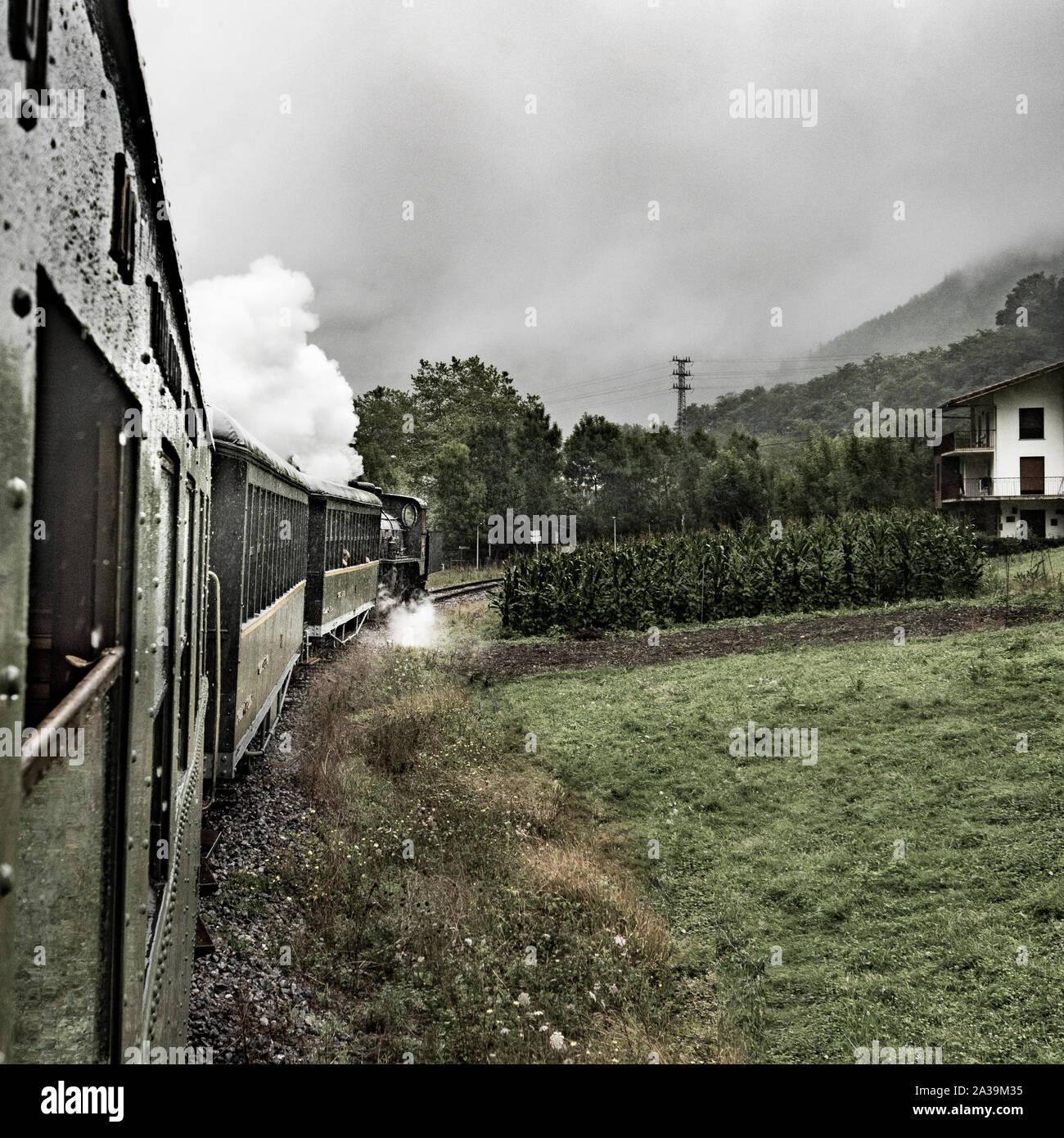 Moving along a curve steam train puffs thick smoke Stock Photo - Alamy