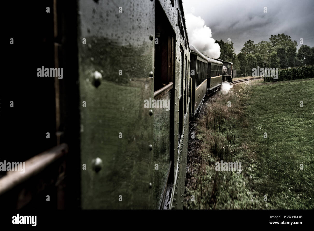 Moving along a curve steam train puffs thick smoke Stock Photo - Alamy