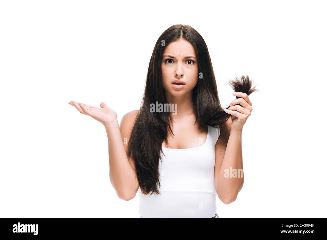 confused beautiful woman looking at long straight damaged hair isolated ...