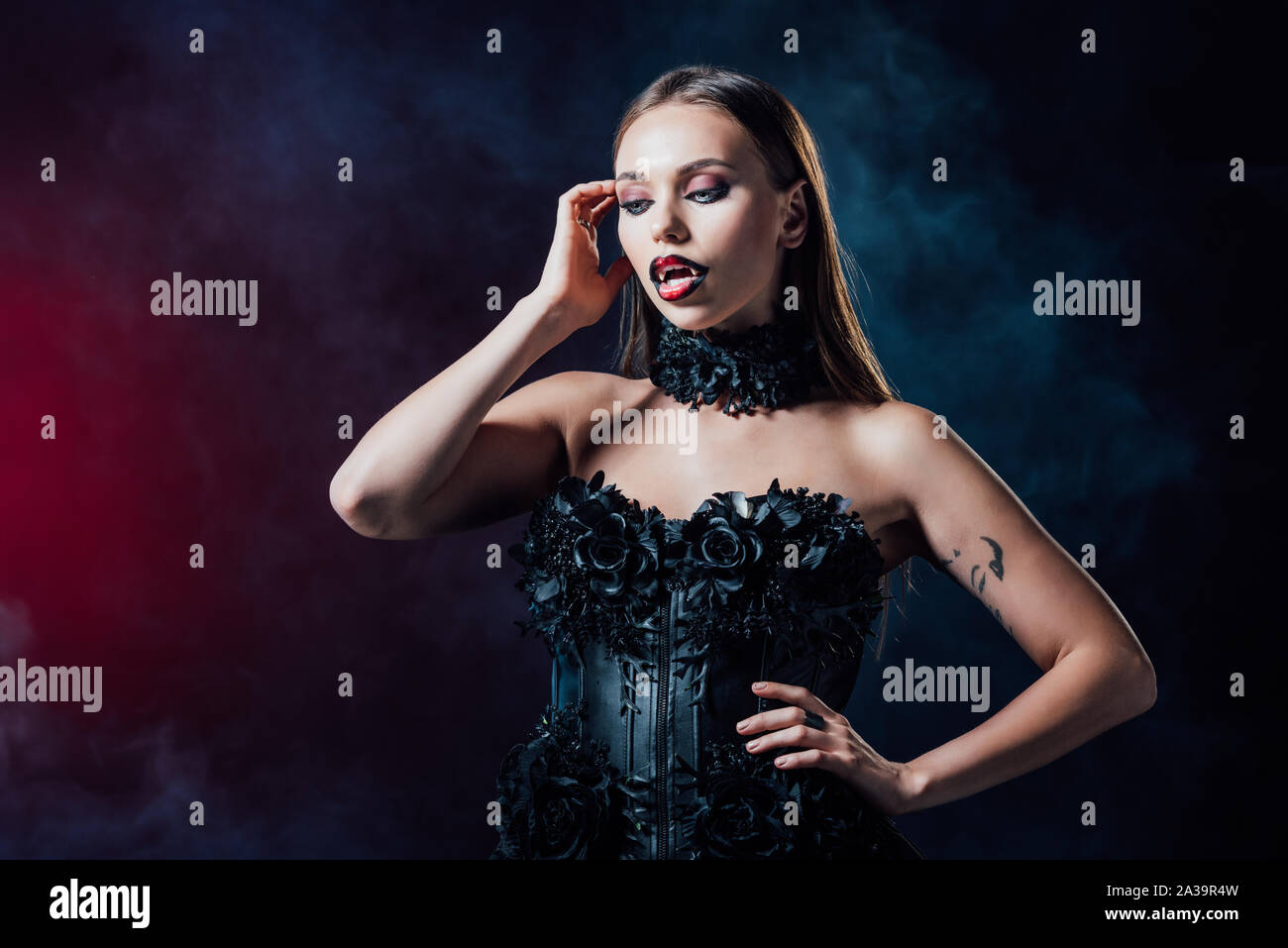scary vampire girl with fangs in black gothic dress on black background ...