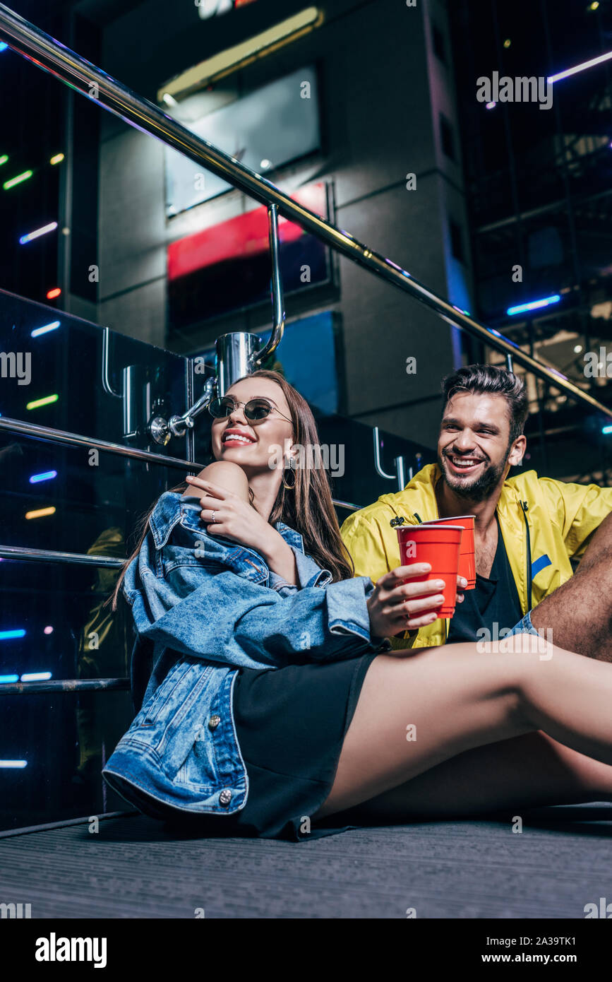 handsome boyfriend with plastic cup and attractive girlfriend pointing ...