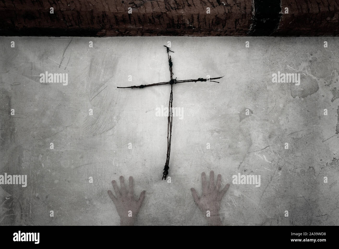 A horror spooky concept. A wooden cross made out of twigs, hanging on a ...