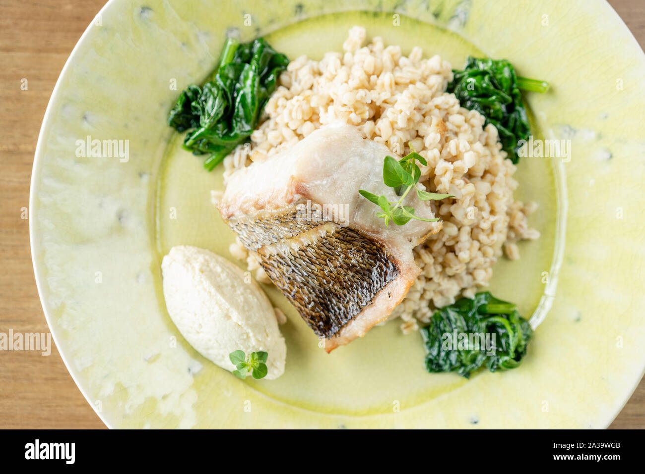 Roasted pike perch or cod fish with bulgur. Dish decorated with a ...