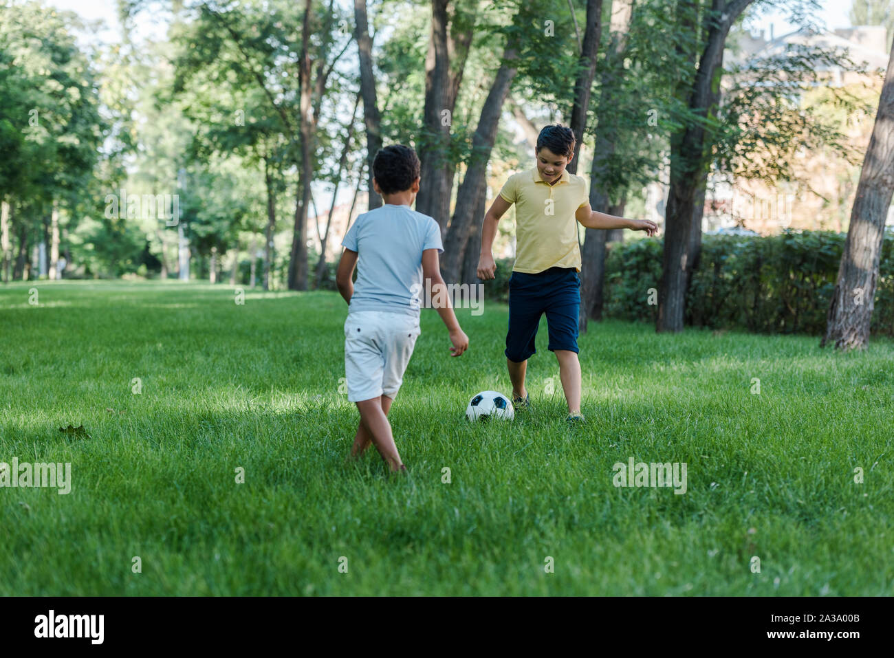 Multicultural children playing football hi-res stock photography and ...