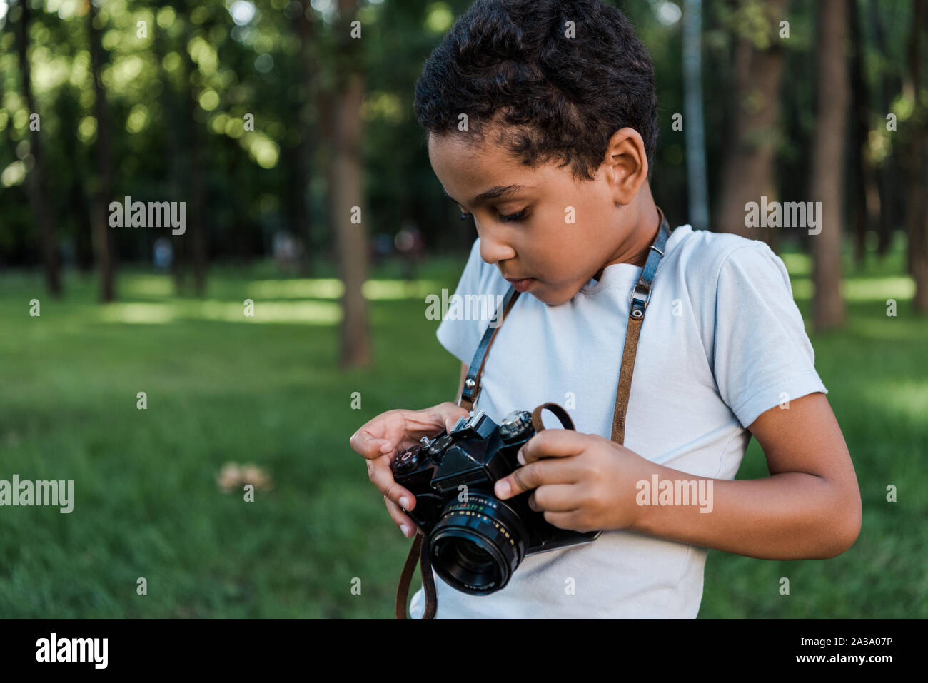cute african american child holding digital camera in park Stock Photo ...