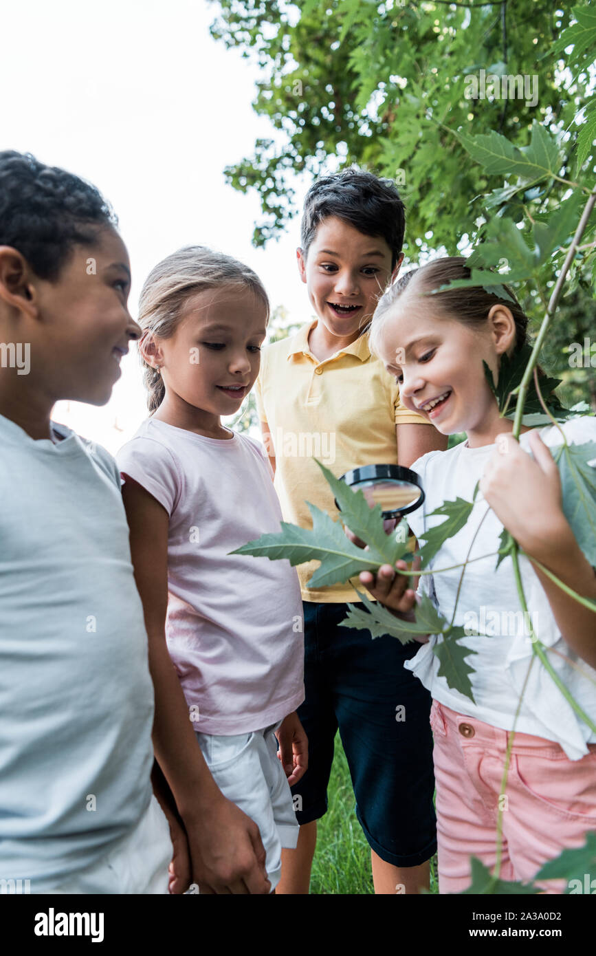 happy multicultural kids looking at green leaves though magnifier Stock ...