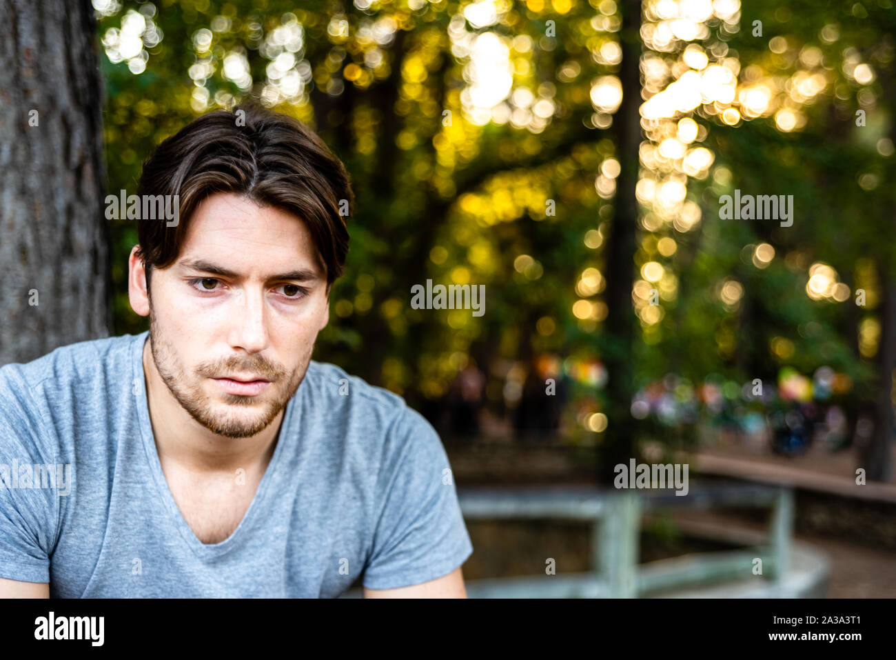 Young man, model, posing outdoors looking tired after a day at work ...