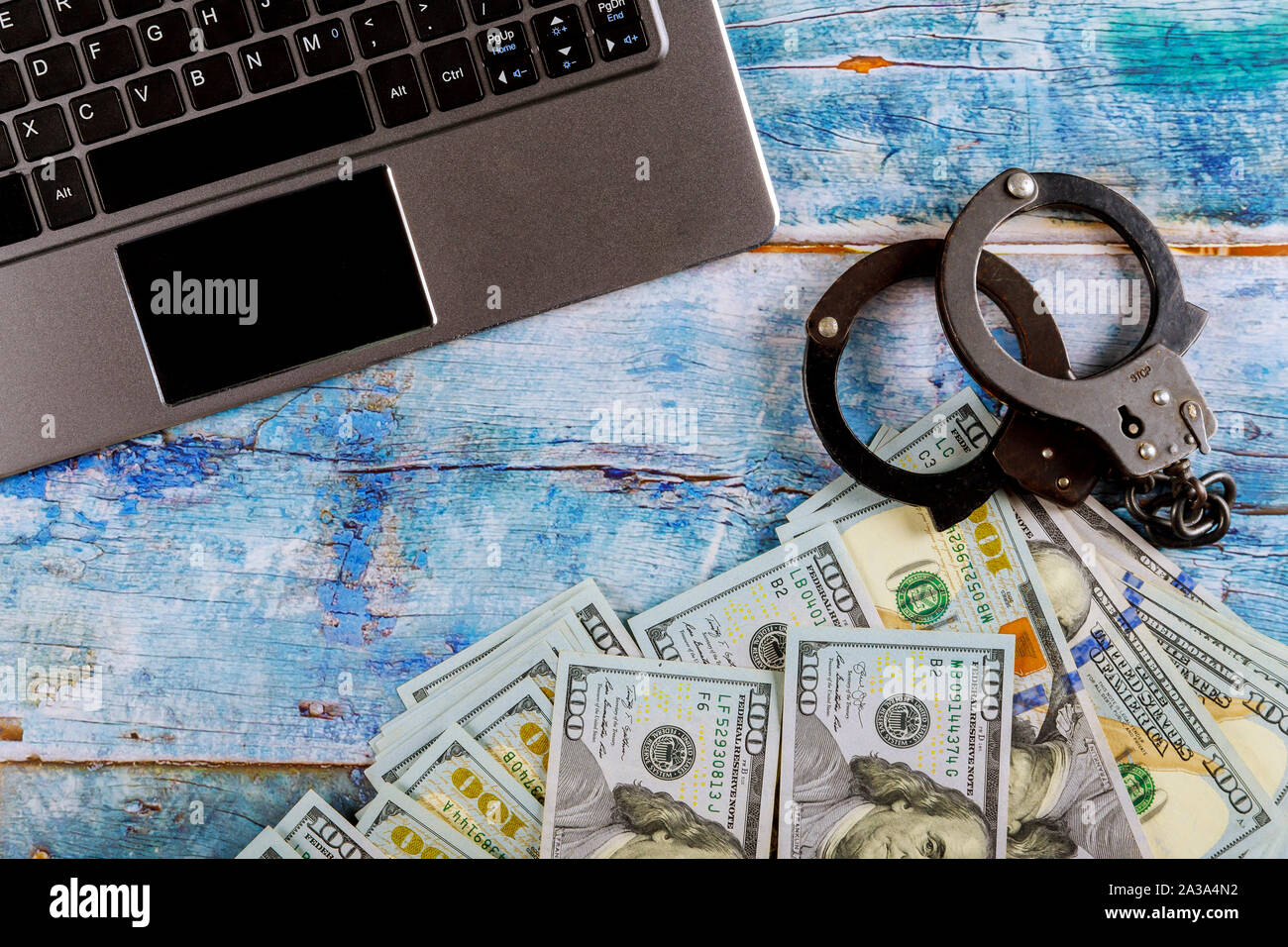 Symbolizing cyber crime, handcuffs on notebook with money american ...