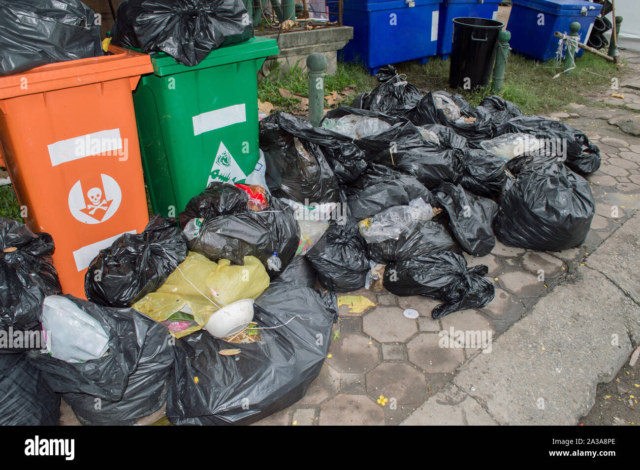 Bin and many garbage piles lots of dumps at the walkway. Pollution and ...