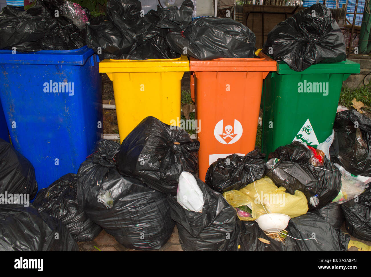 Bin and many garbage piles lots of dumps at the walkway. Pollution and ...