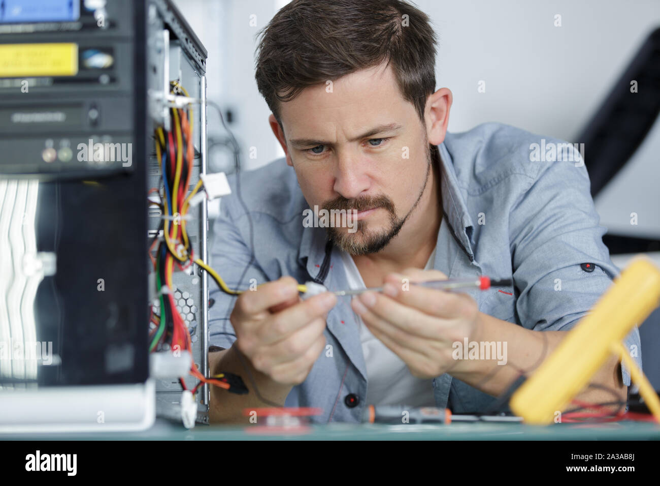 concentrated man connecting a cable onto a circuit board Stock Photo ...
