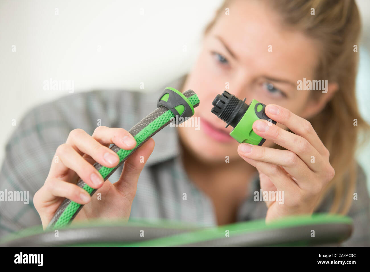 a woman is fixing a hose Stock Photo - Alamy