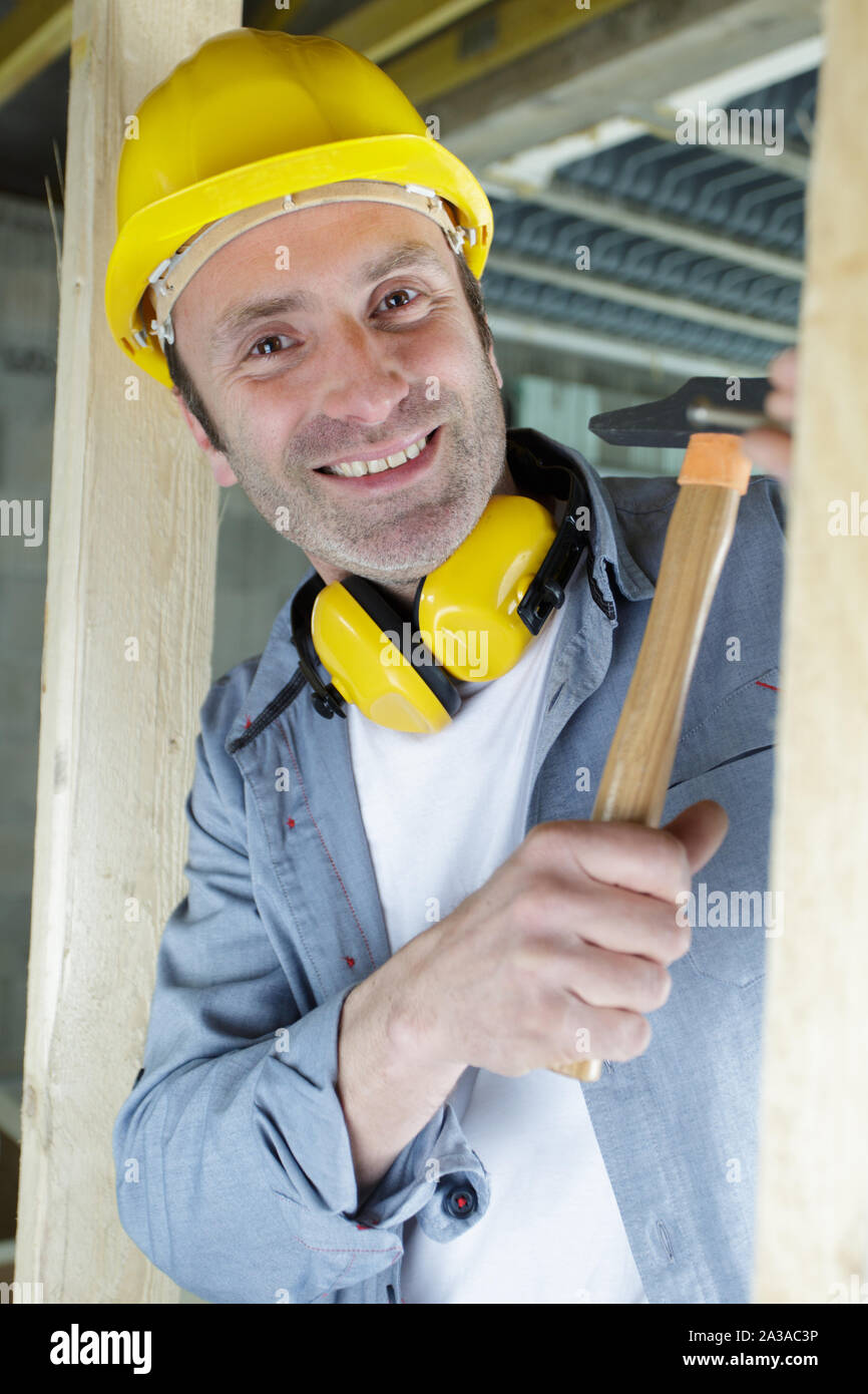 happy builder with a hammer and nail Stock Photo - Alamy