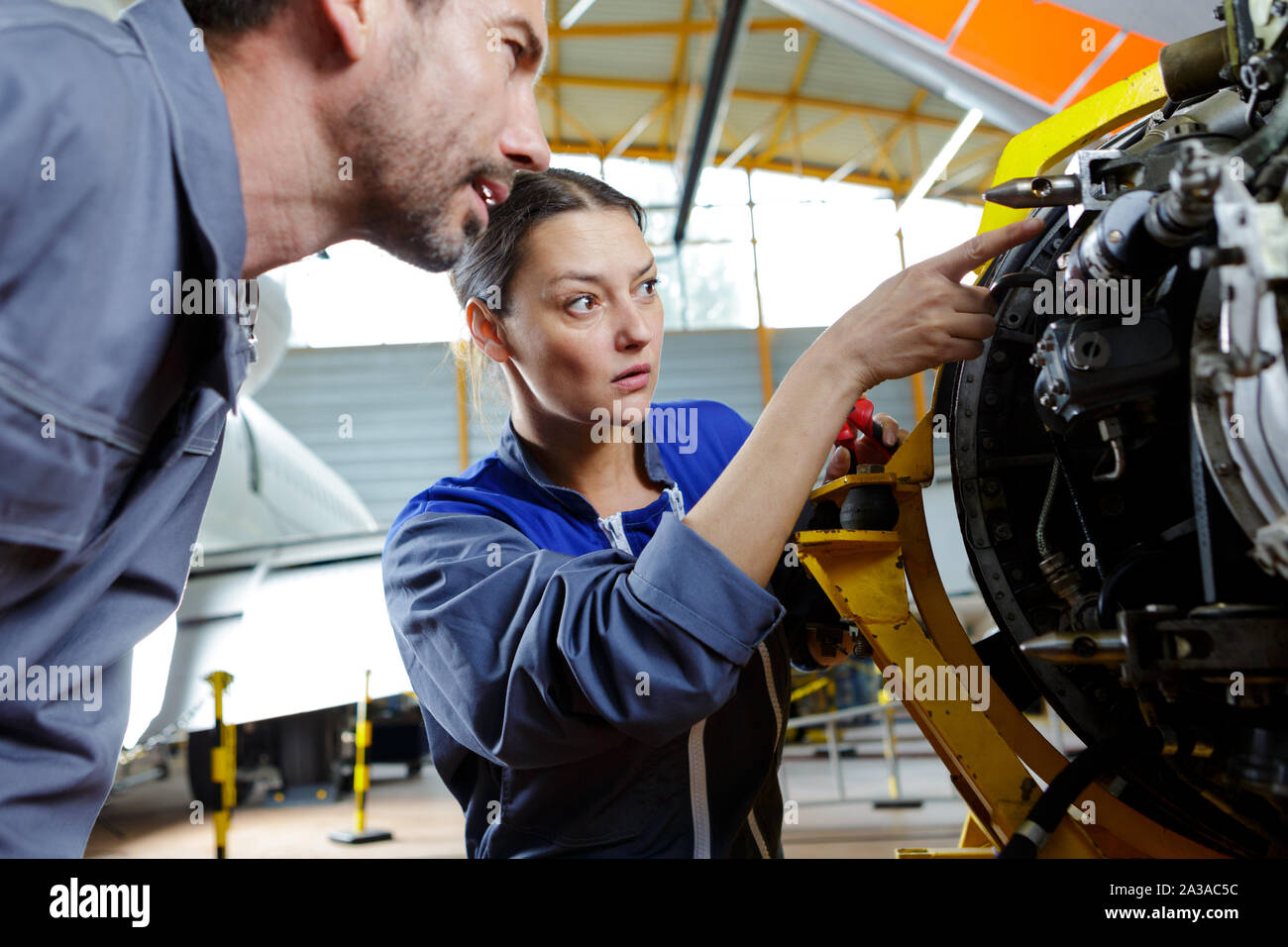 female mechanic fixing a compressor engine Stock Photo - Alamy