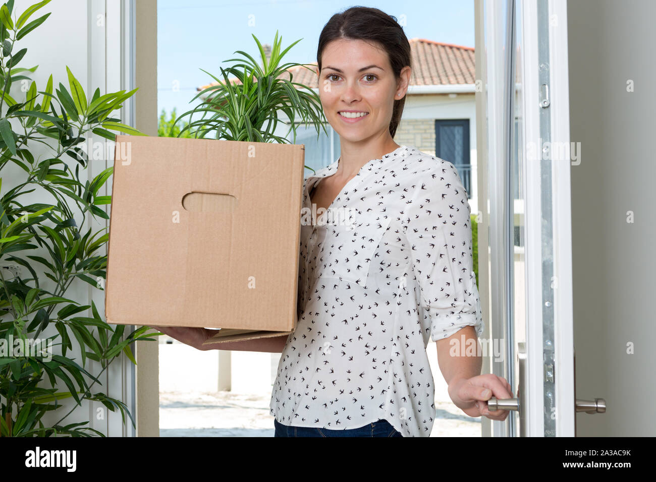 Woman walking out of door smiling hi-res stock photography and images ...