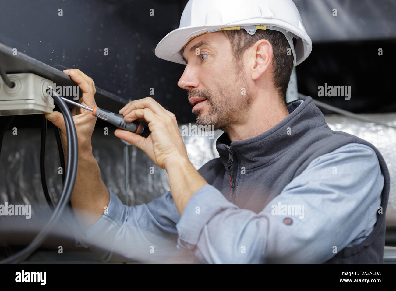 an electrician performs electrical work Stock Photo - Alamy
