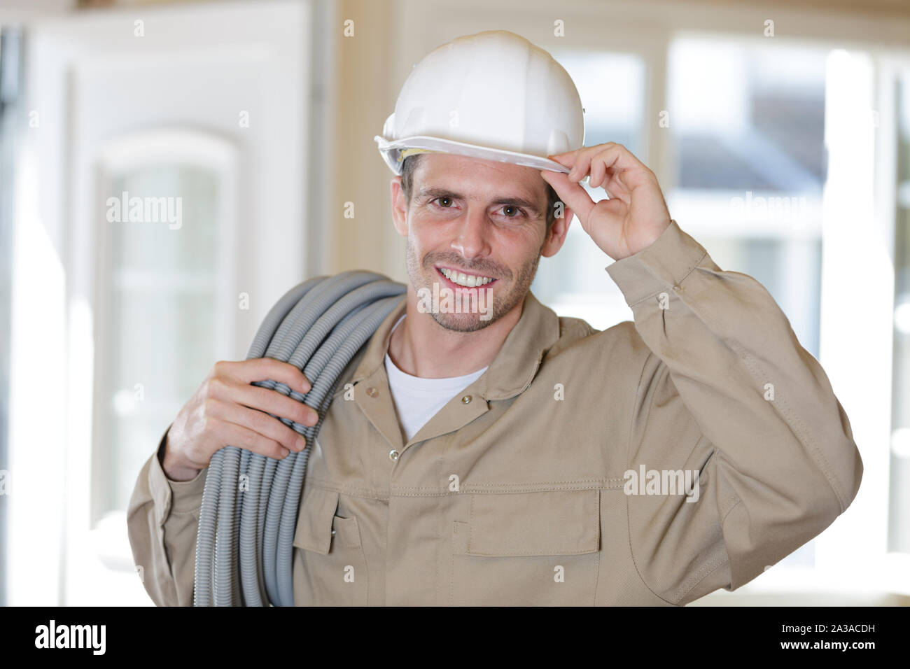 male carpenter carrying cables indoors Stock Photo - Alamy