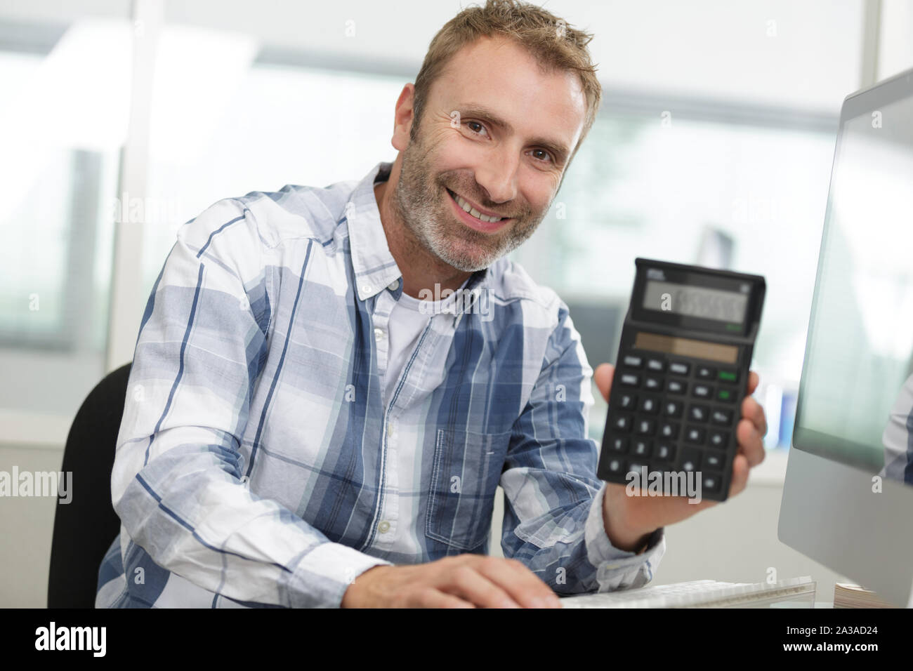 a smiling businessman holding calculator Stock Photo - Alamy