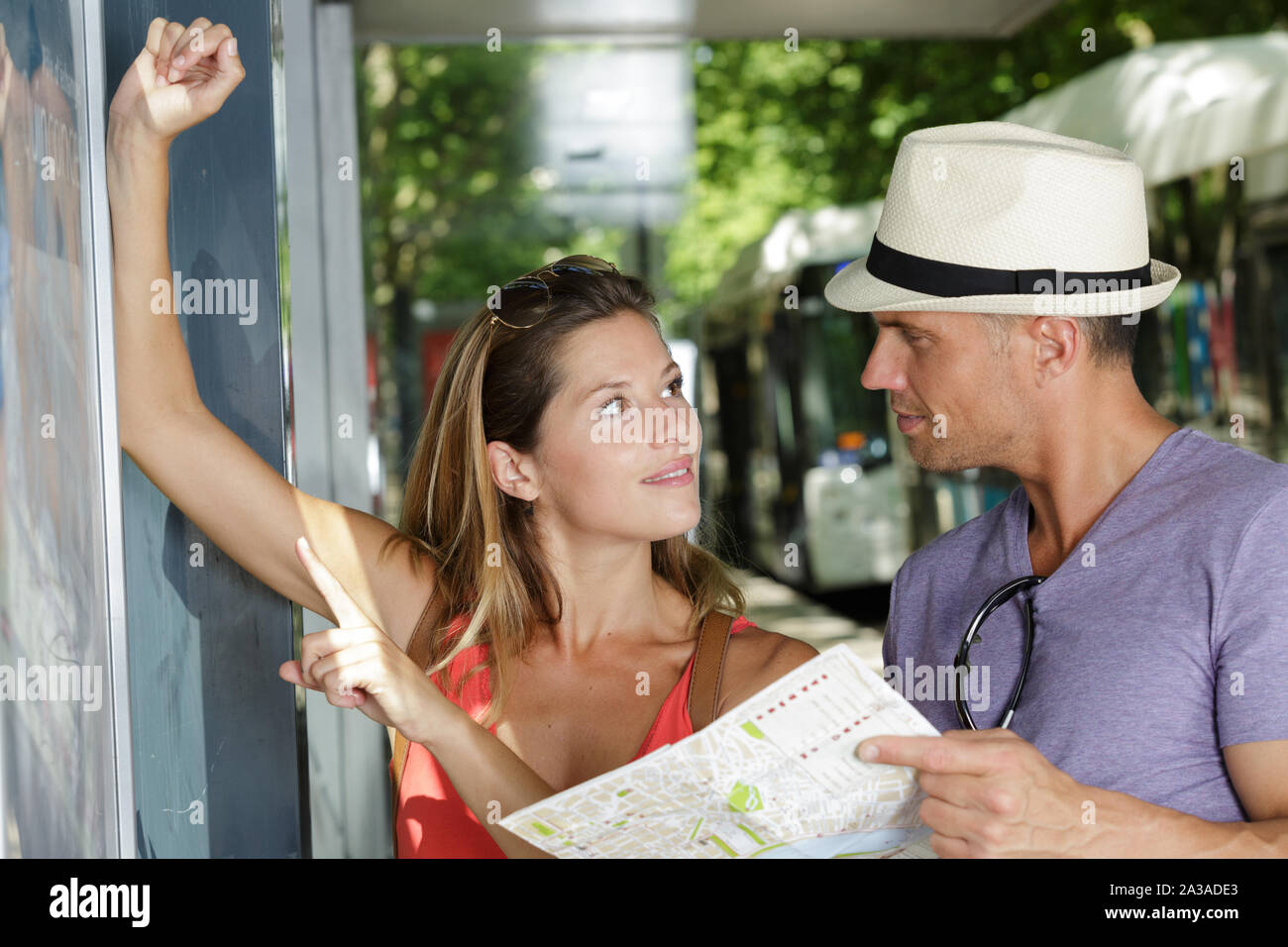 woman and man checking a bus at bus stop Stock Photo - Alamy