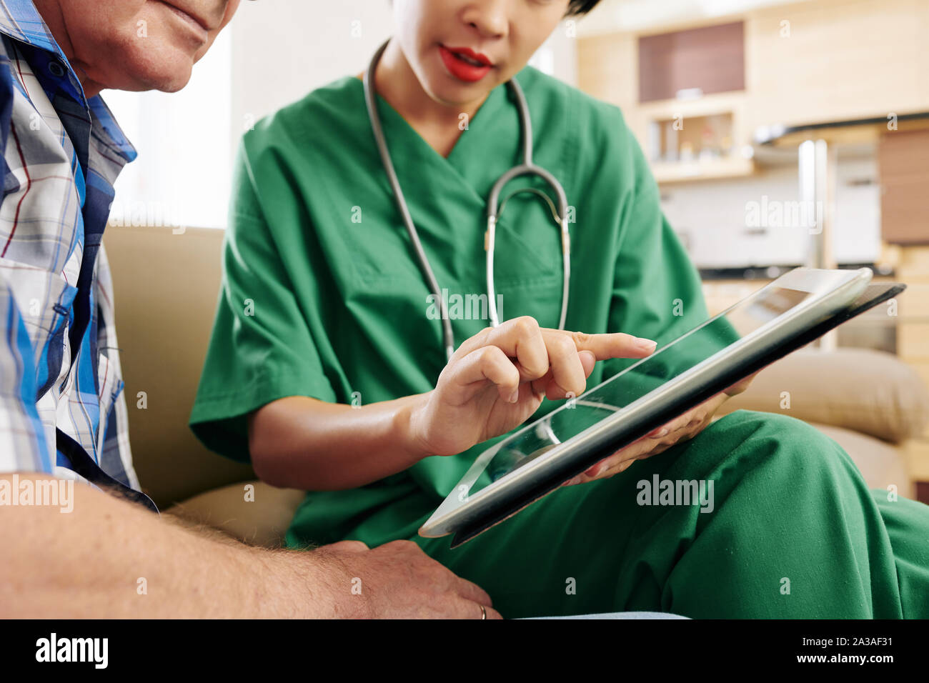 Caregiver explaining senior patient how to use health application on ...