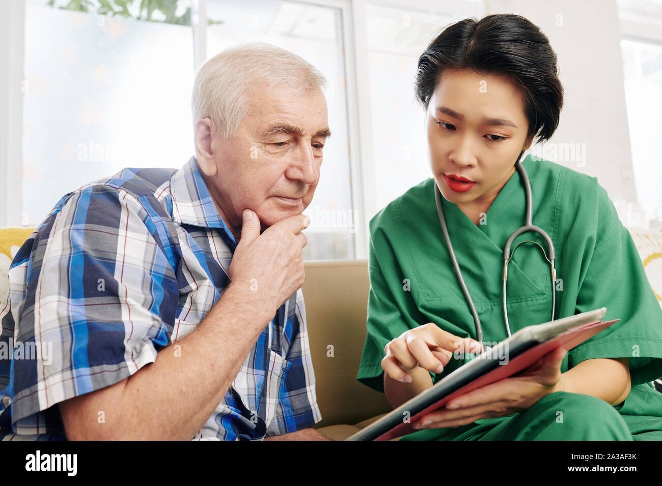 Concerned senior man reading medical tests results on talbet computer ...
