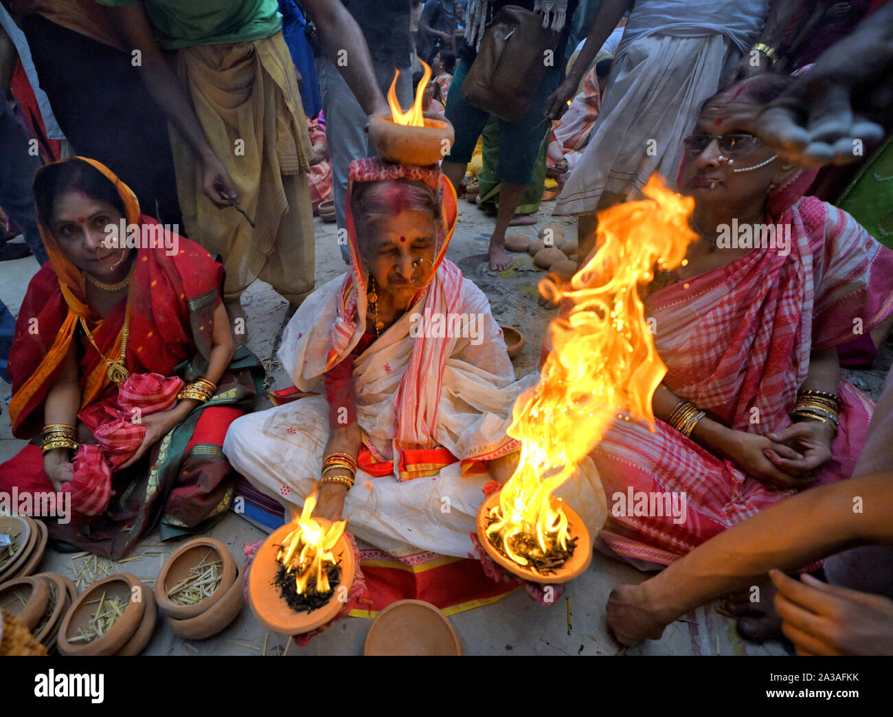 Kolkata, India. 06th Oct, 2019. Indian hindu women sit with burning ...