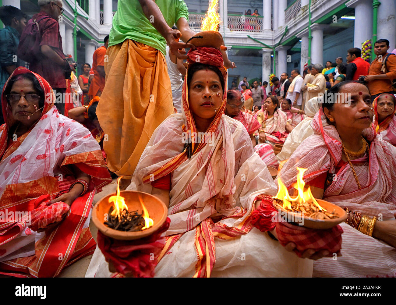 Kolkata, India. 06th Oct, 2019. Indian hindu women sit with burning ...