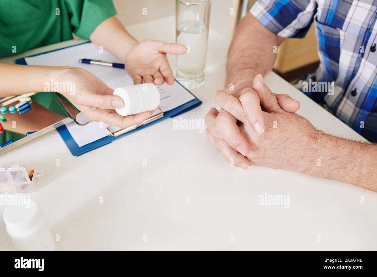 Hands of doctor giving bottle of tables to senior patient and giving ...