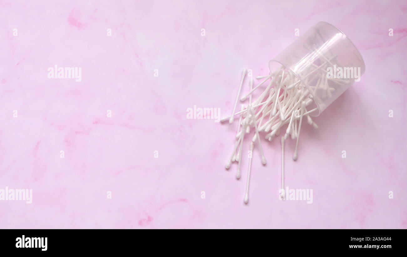 A transparent container tip over with cotton buds spilling out from it ...