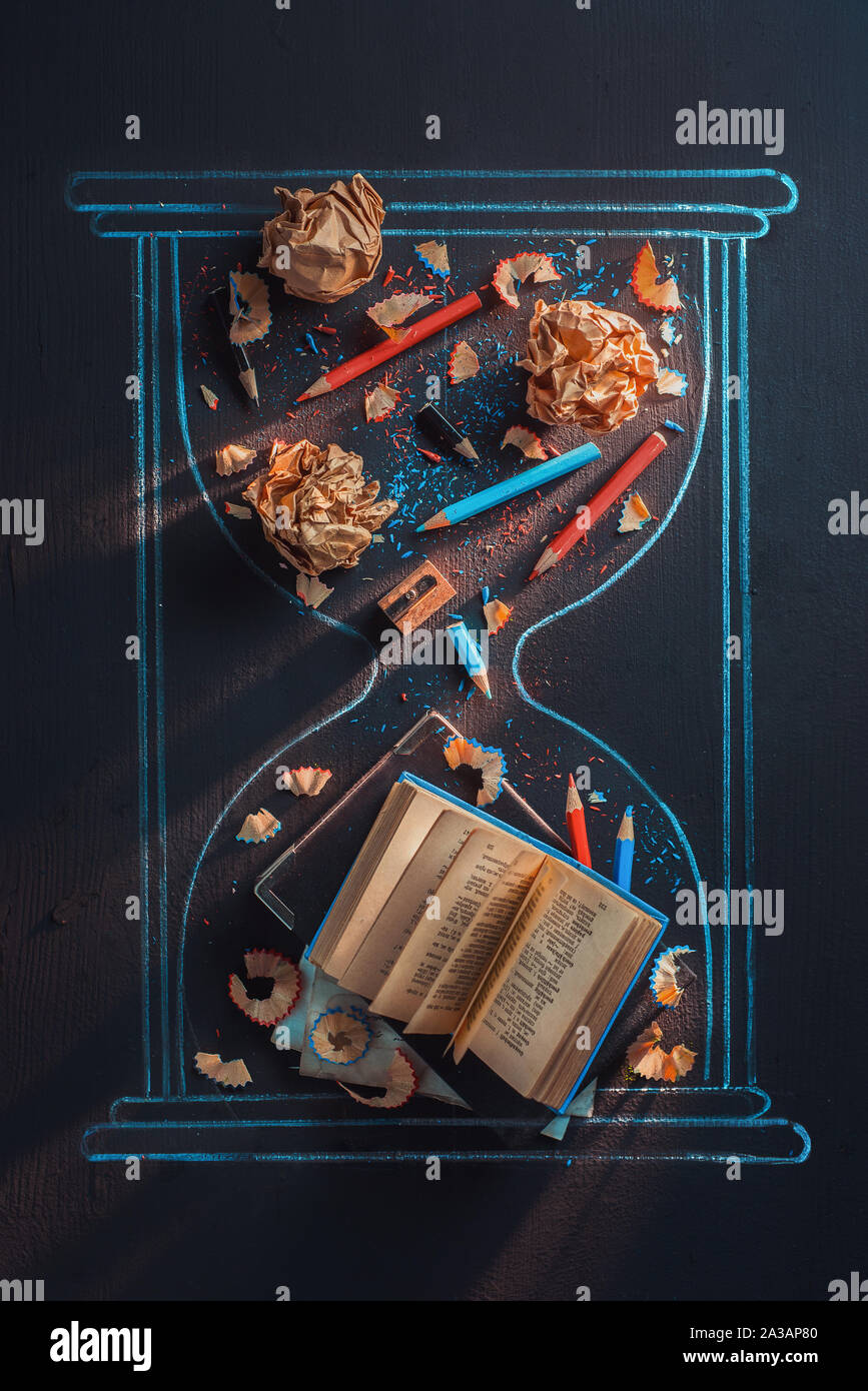 Chalk hourglass drawing with books, crumpled paper, and pencils ...
