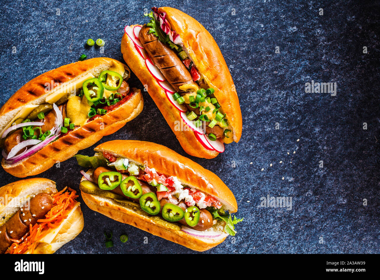 Hot dogs with different toppings on a dark blue background. Fast food ...