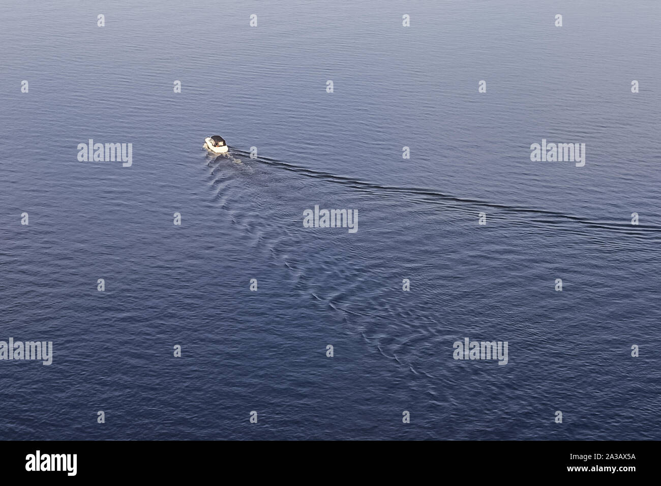 Boat wake on water surface in sunset light Stock Photo - Alamy